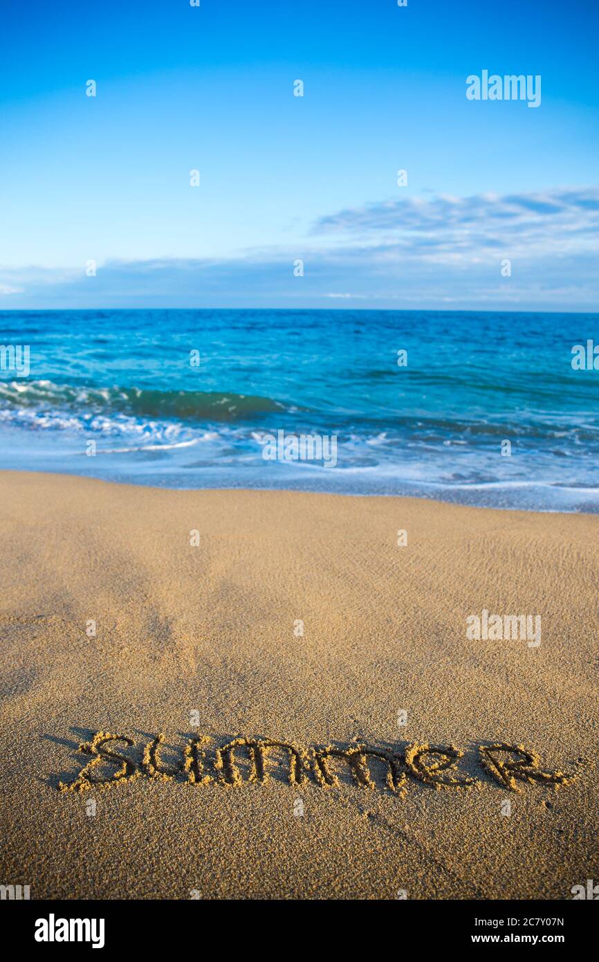 sunny beach background with word summer written in sand Stock Photo - Alamy