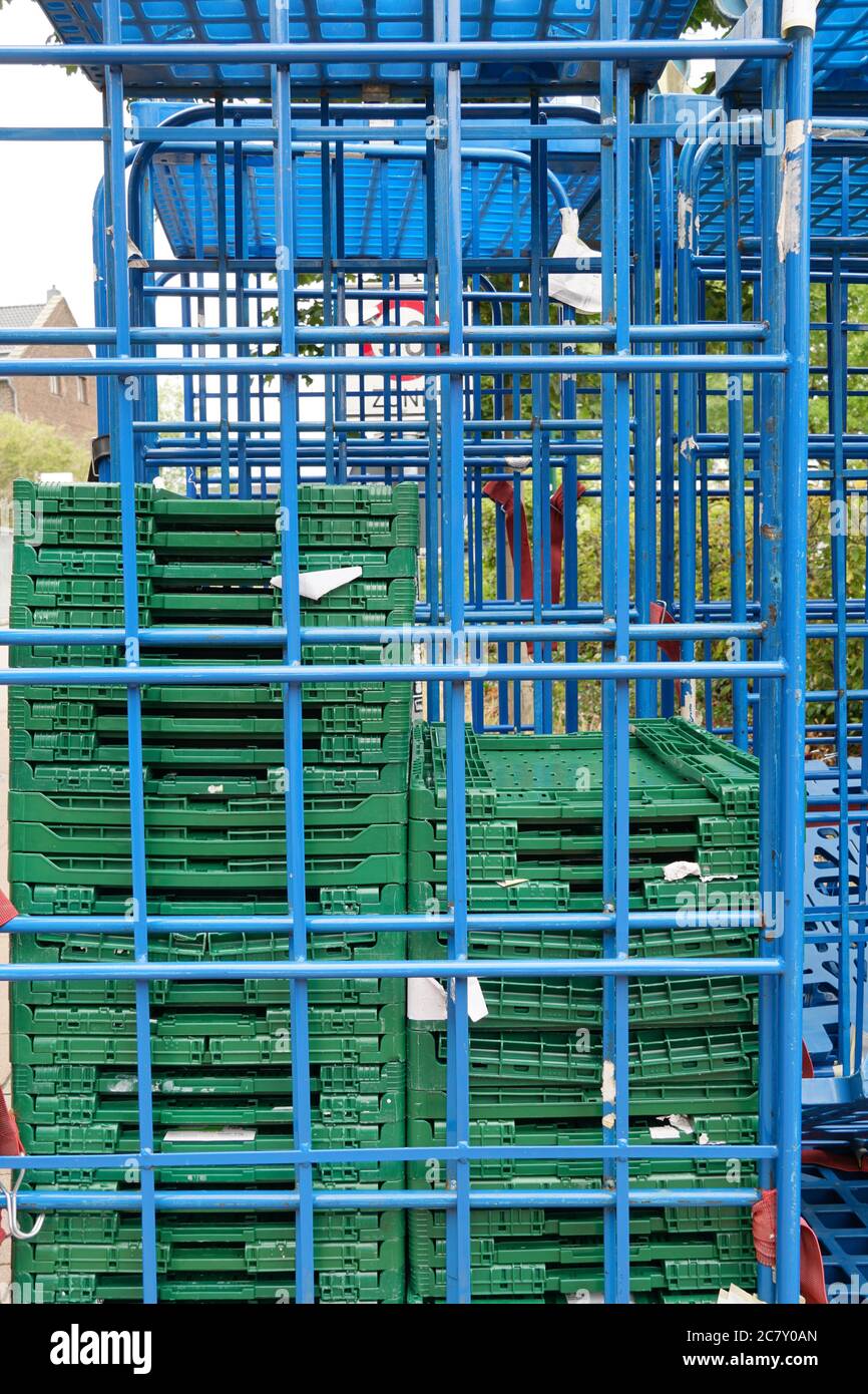 Vertical shot of foldable plastic boxes in a metal rag at a grocery ...