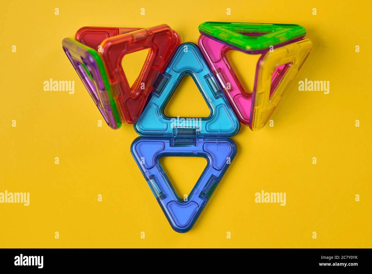 Top view of colorful magnetic building blocks on yellow background ...