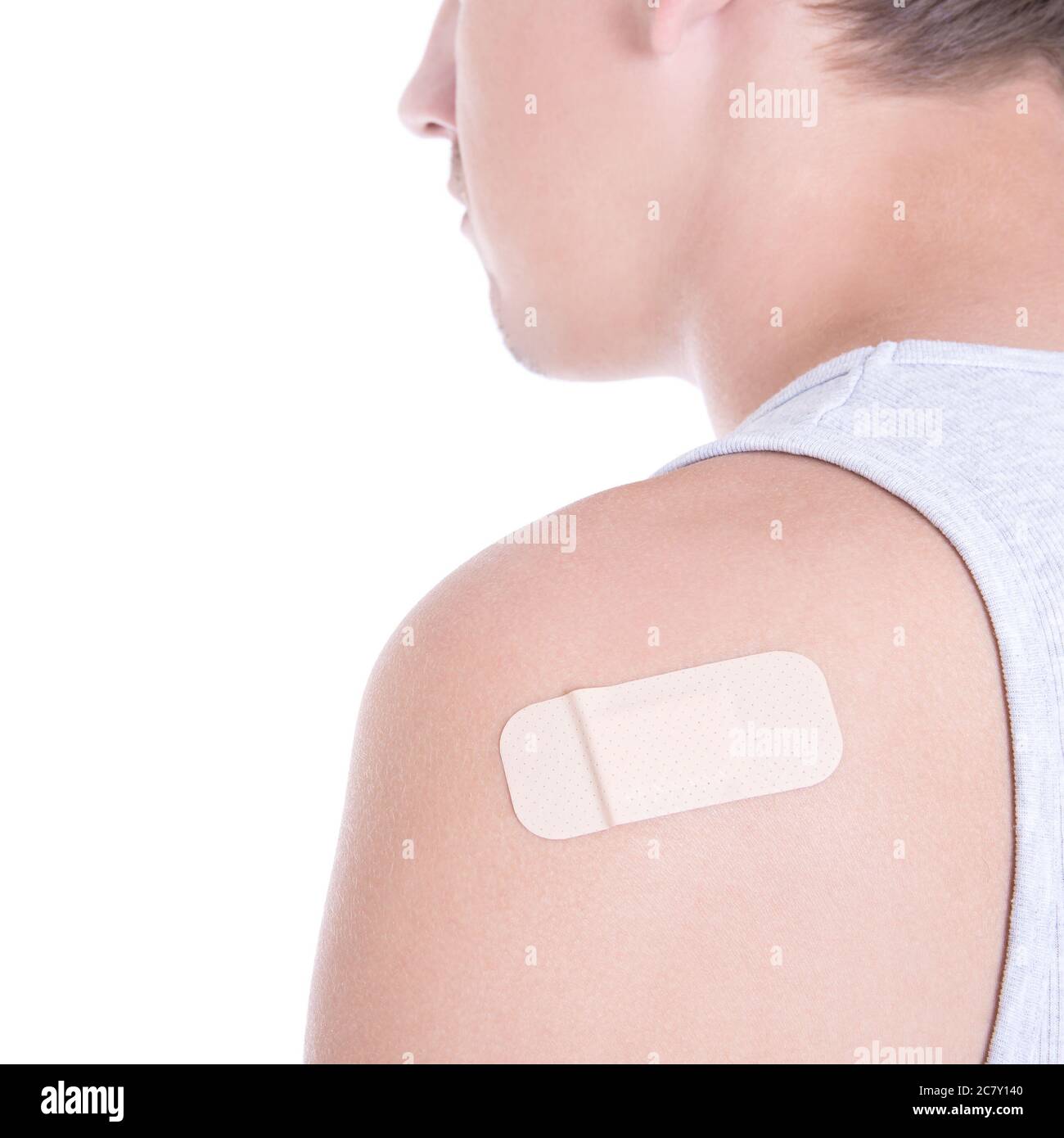 close up of medical adhesive plaster on male shoulder isolated on white ...