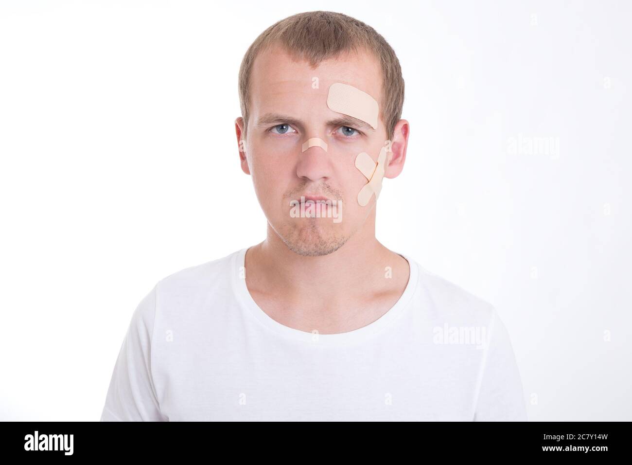 portrait of sad and injured young man with adhesive plaster on his face ...