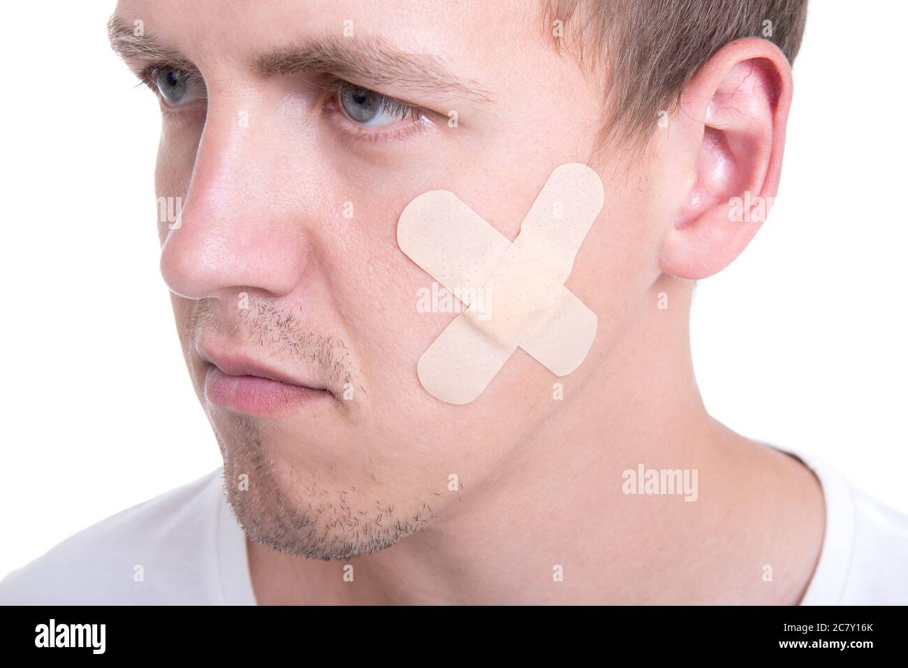 close up portrait of injured young man with adhesive plaster on his ...