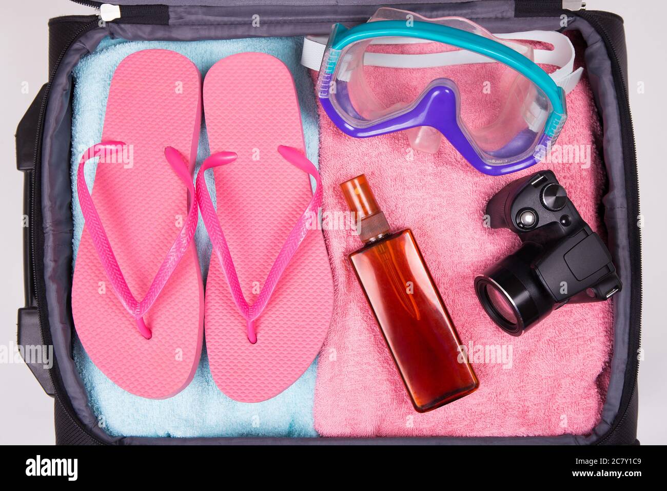 summer vacation concept - packed suitcase full of colorful vacation ...