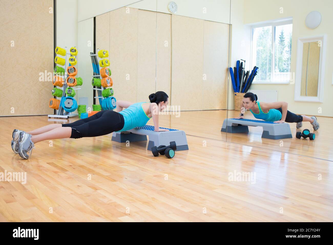 young beautiful slim woman doing push ups with stepper in gym Stock ...