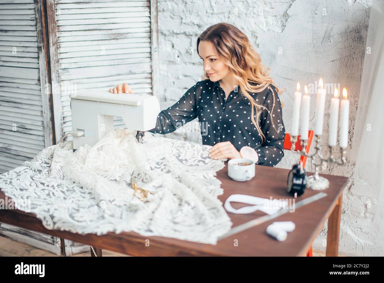 Tailor working in the shop using industrial grade tailoring machine ...