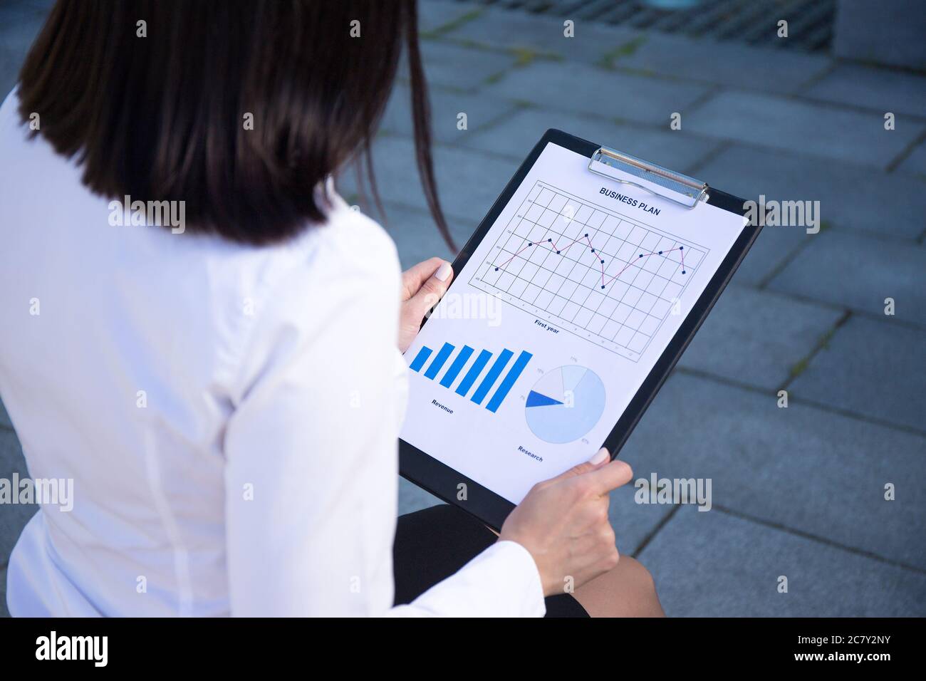 business plan concept - woman holding clipboard with different charts ...