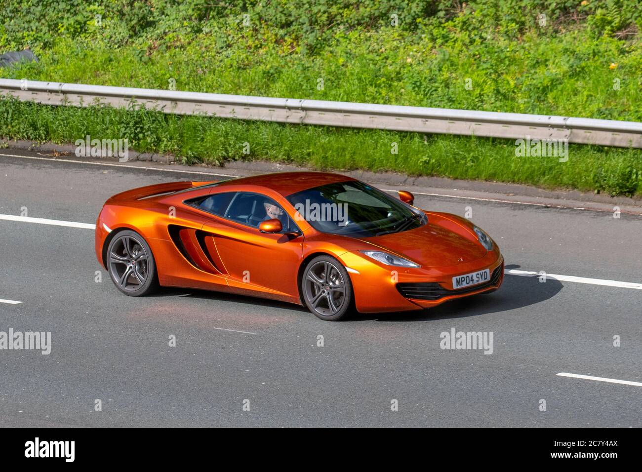 2011 orange Mclaren sportscar roadster; Vehicular traffic moving ...