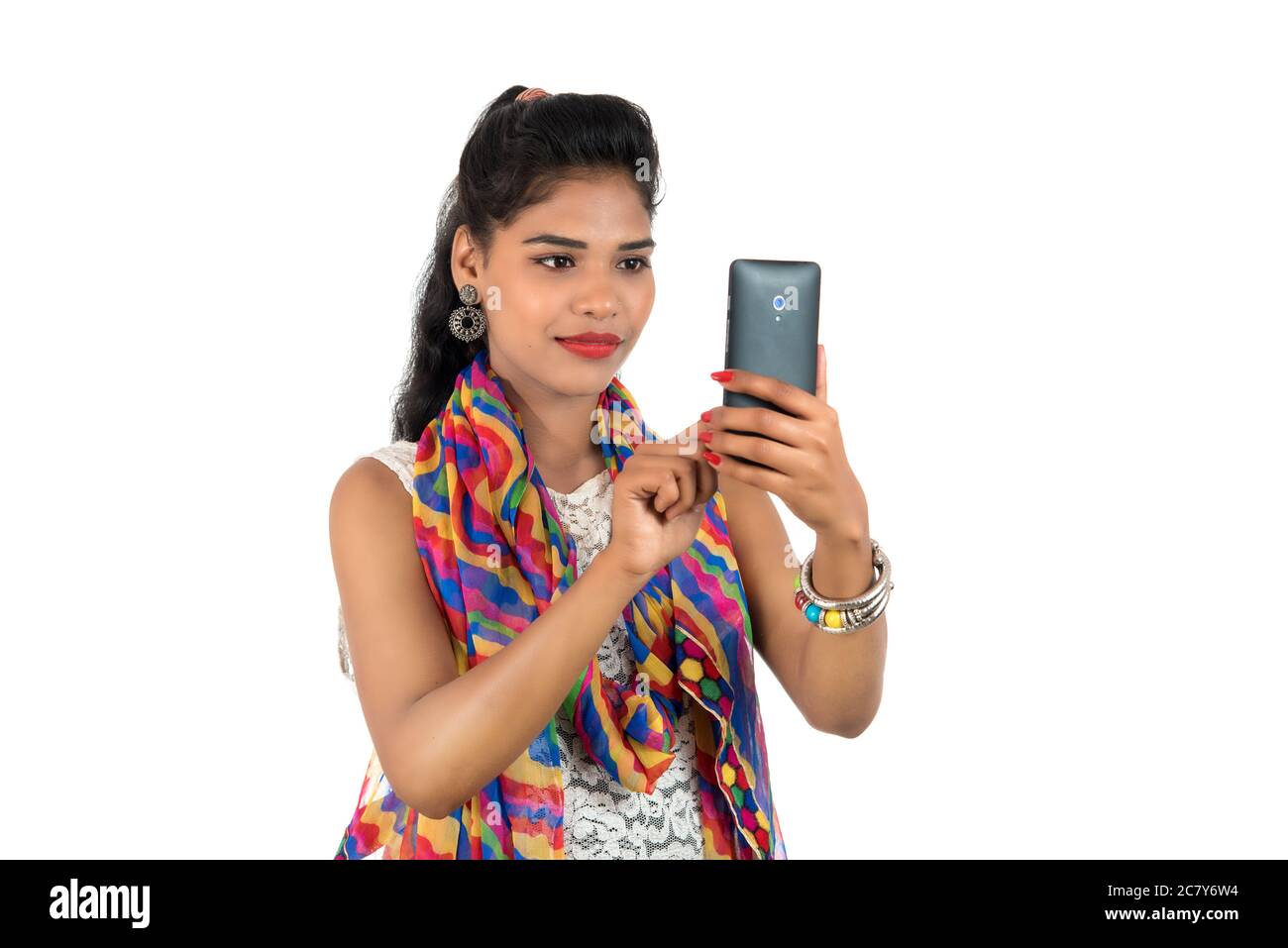 Young Indian girl using a mobile phone or smartphone isolated on a ...