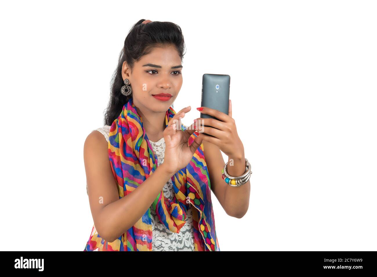 Young Indian girl using a mobile phone or smartphone isolated on a ...