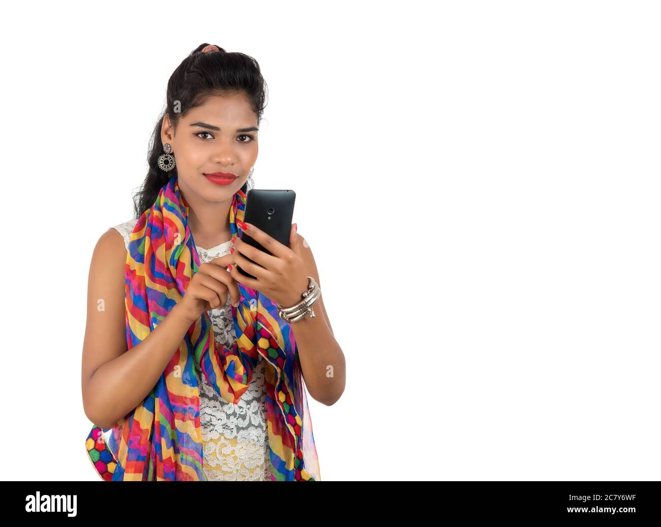 Young Indian girl using a mobile phone or smartphone isolated on a ...