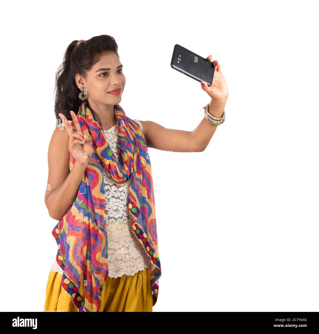 Young Indian girl using a mobile phone or smartphone isolated on a ...