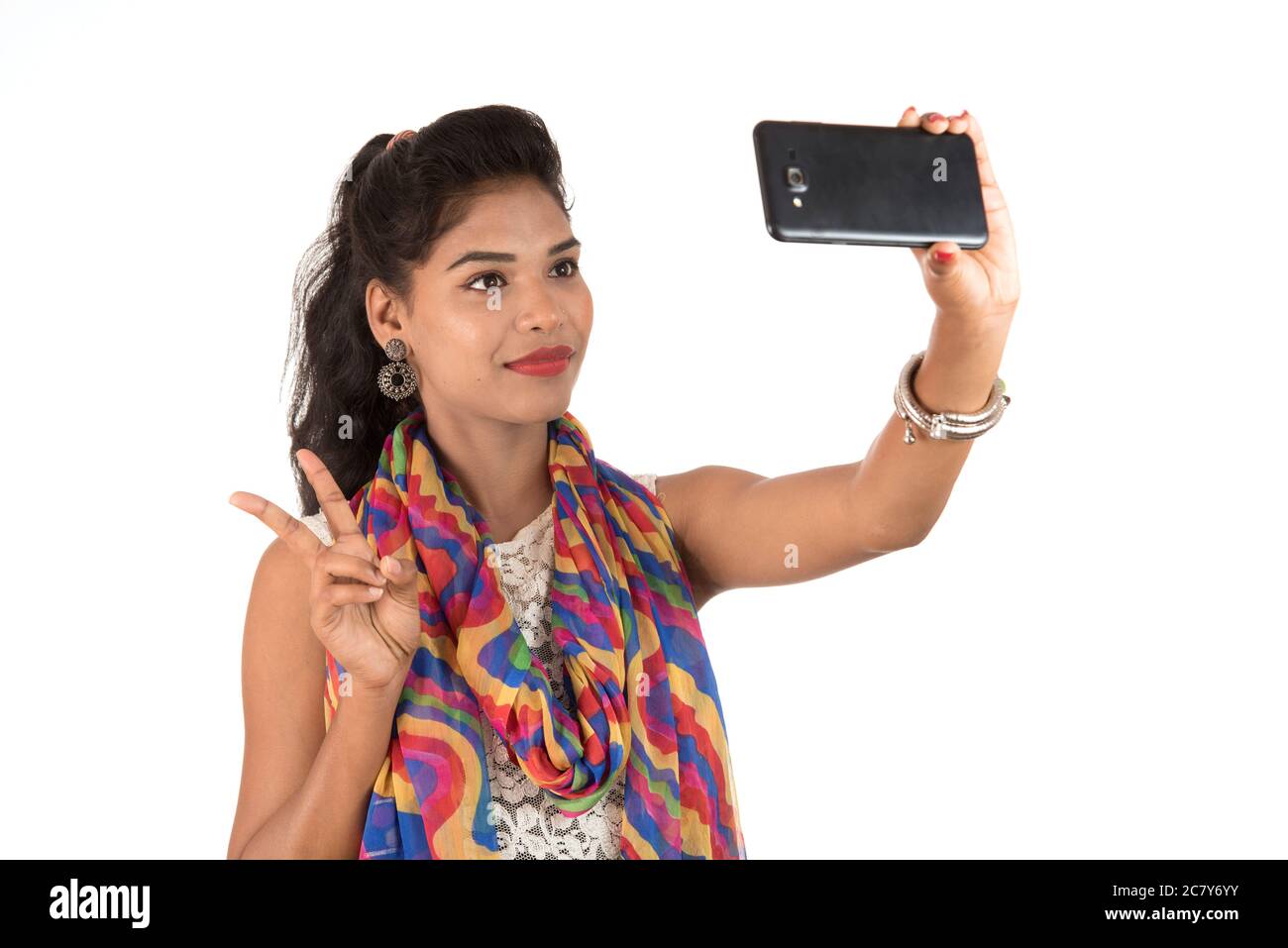 Young Indian girl using a mobile phone or smartphone isolated on a ...