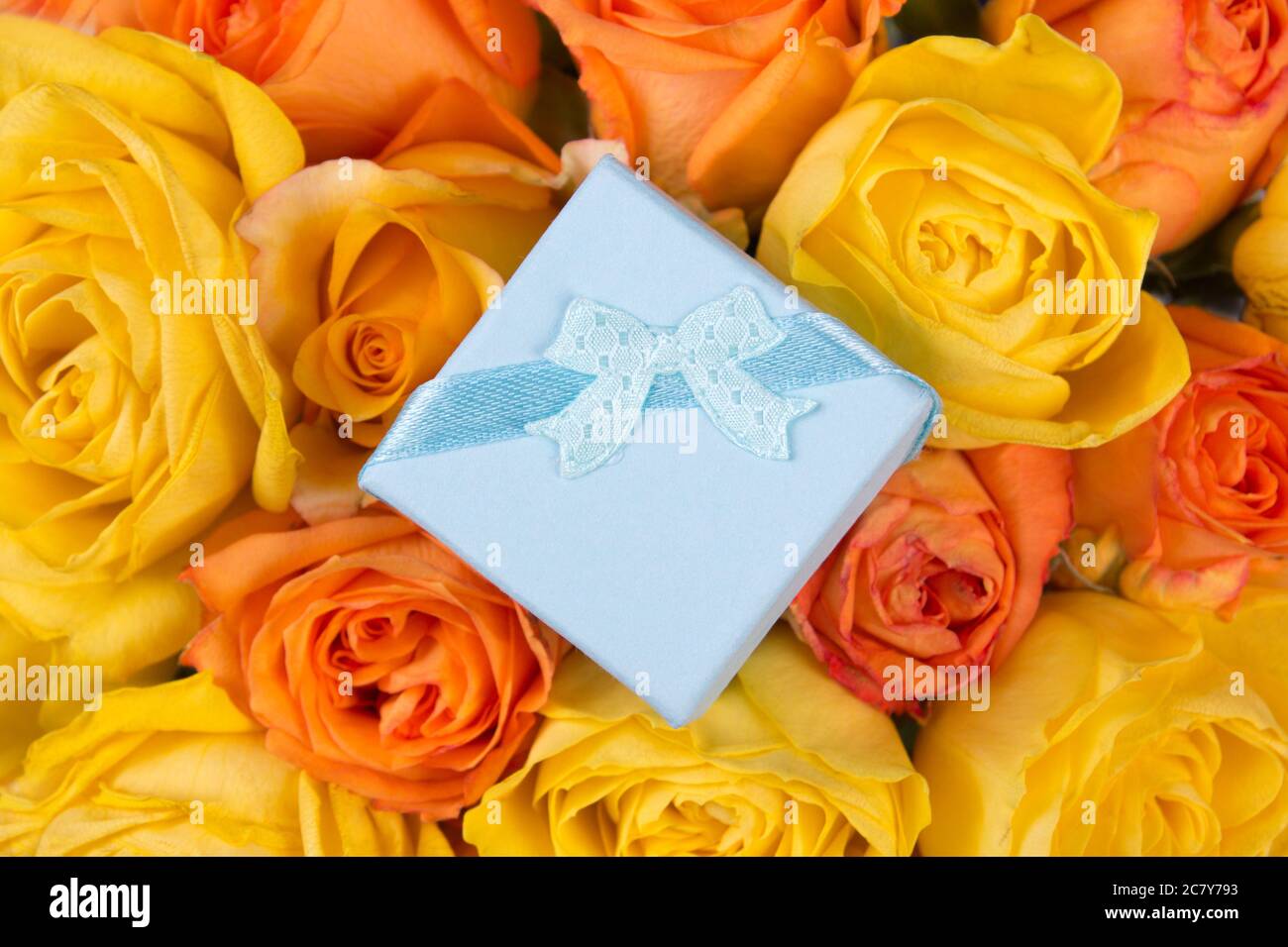 little blue gift box and beautiful bouquet of orange and yellow roses ...