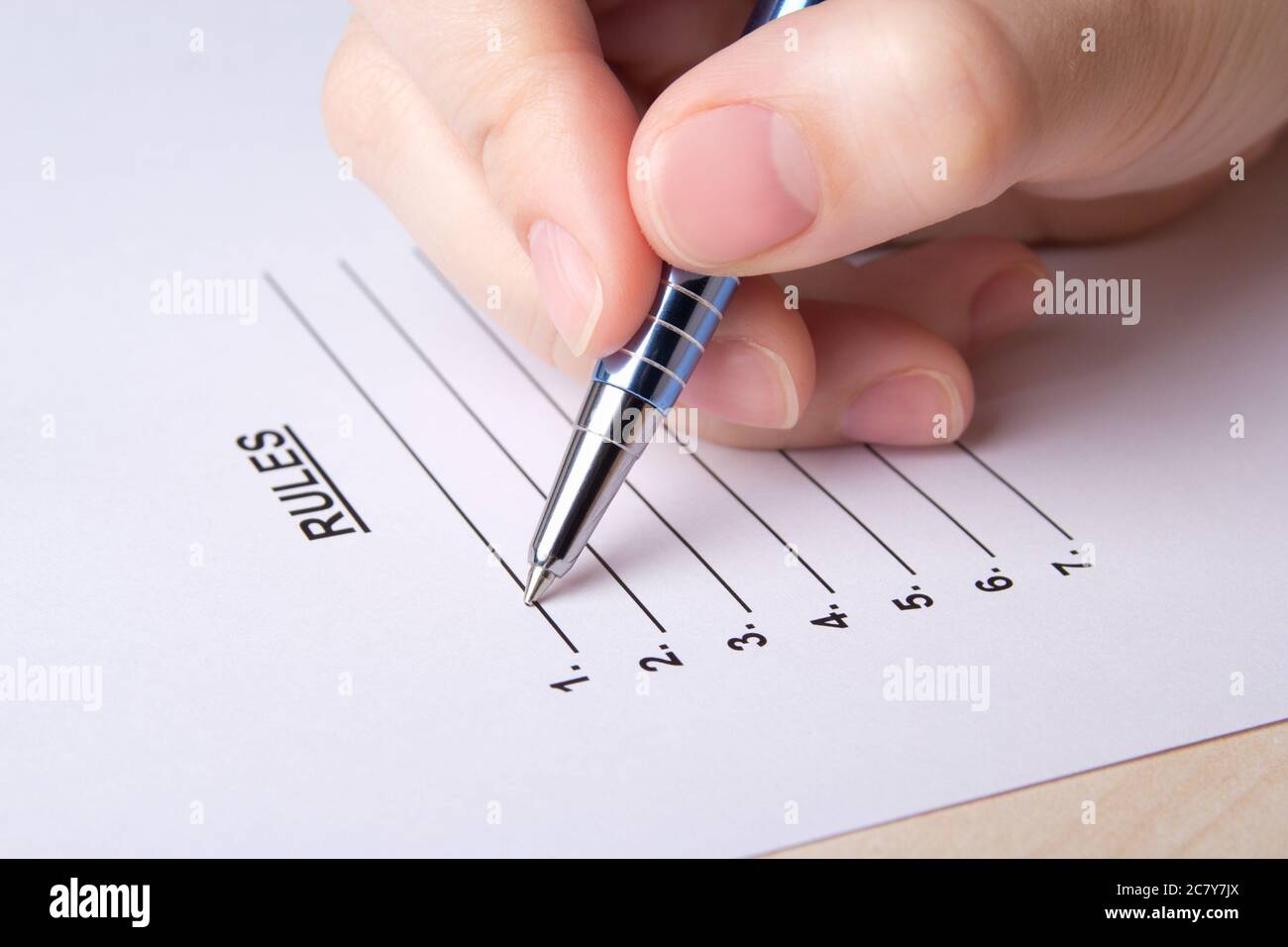 female hand filling rules list with blue pen Stock Photo - Alamy