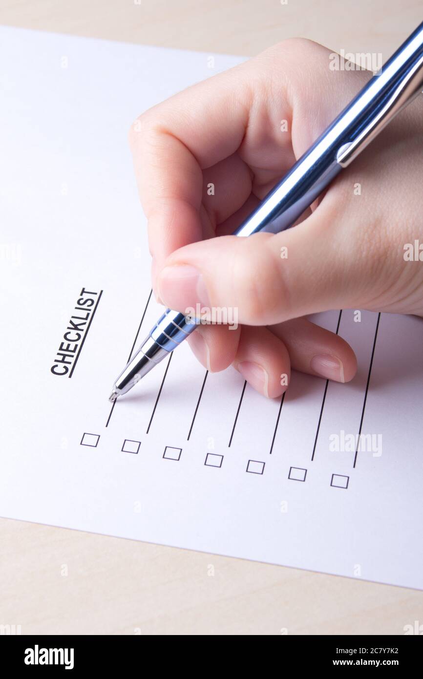 female hand filling blank checklist with pen Stock Photo - Alamy