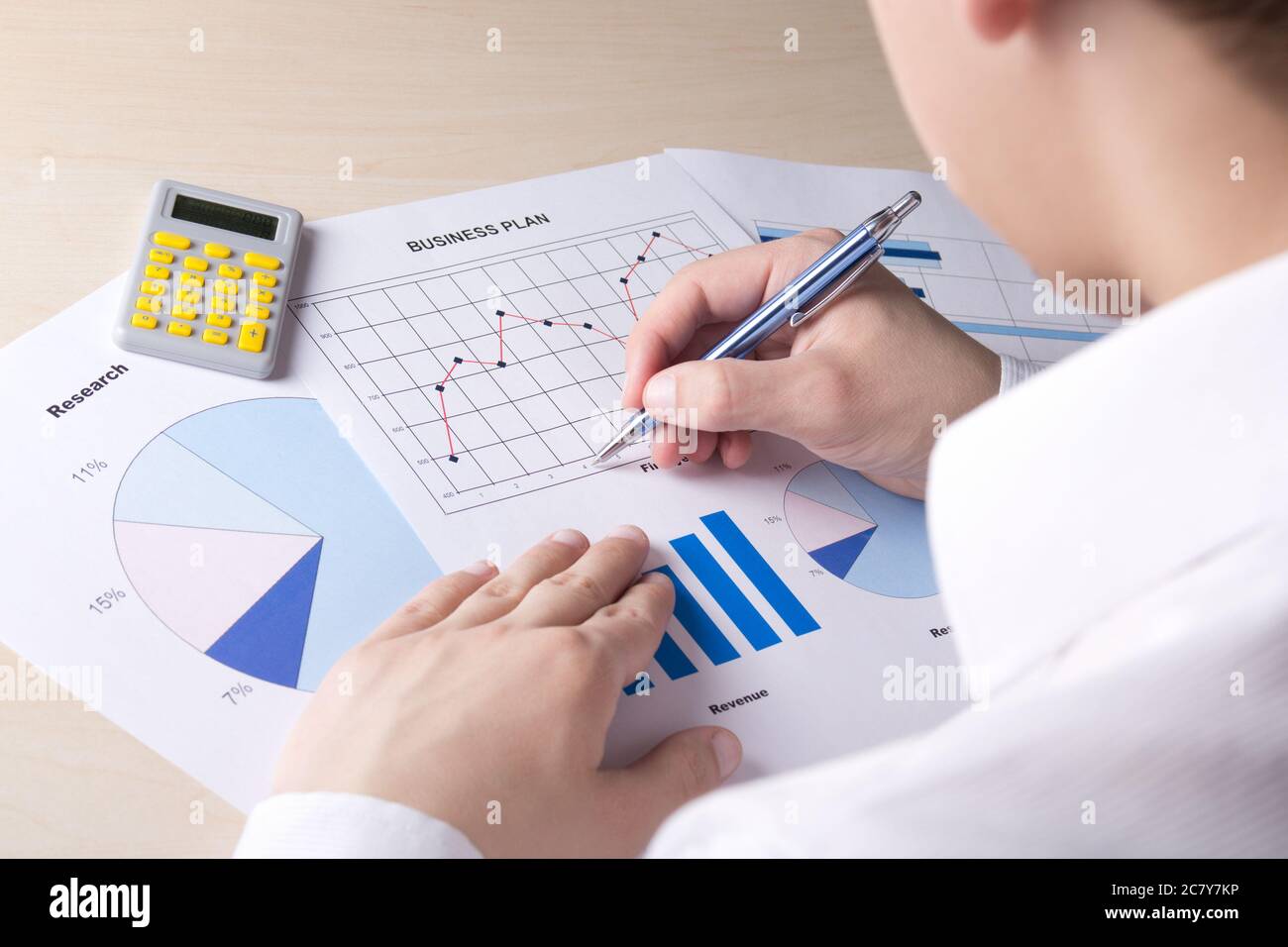 back view of bussinessman accounting something with calculator in ...