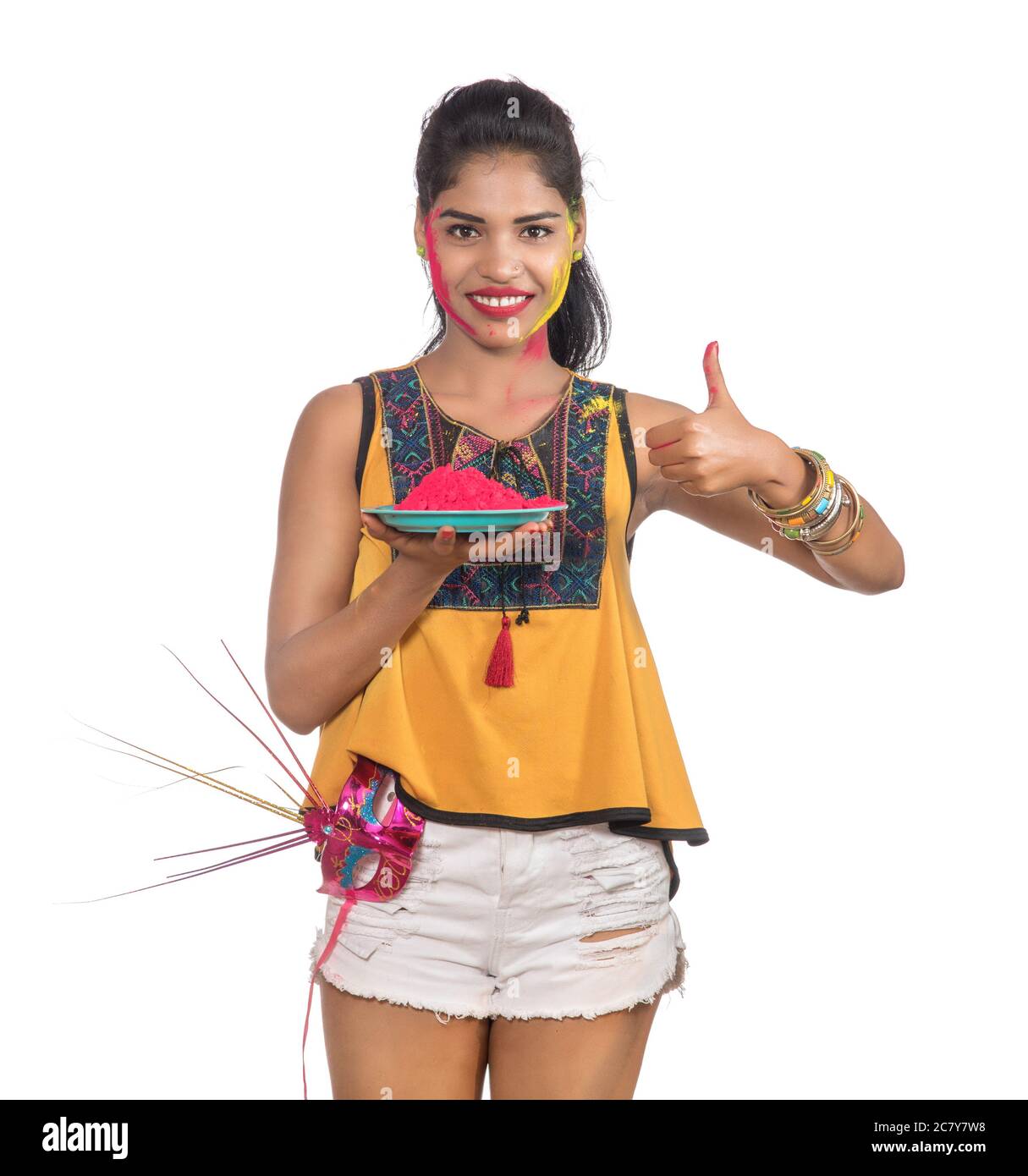 Beautiful young girl holding powdered color in plate with carnival mask ...