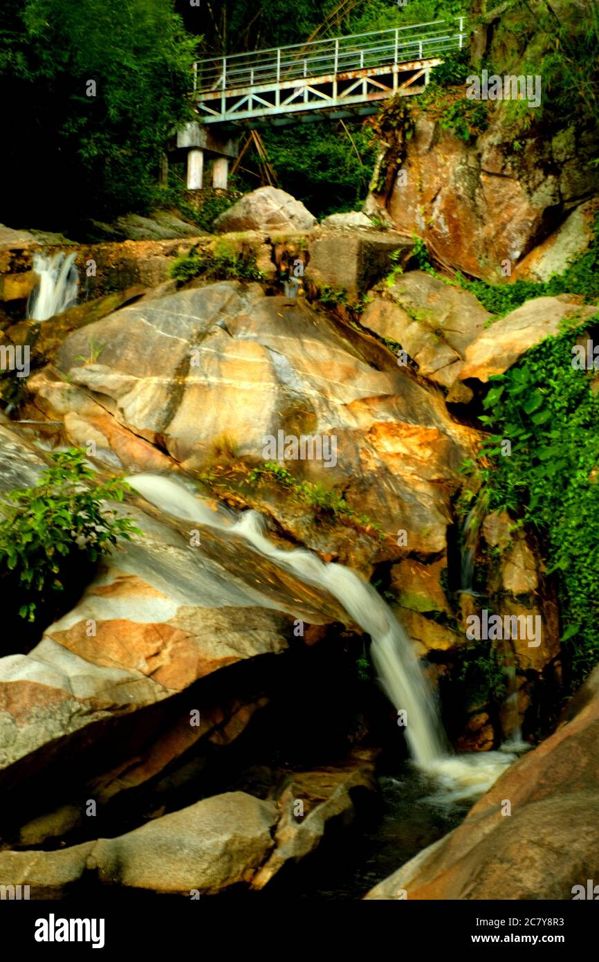 The flowing tide of water through rocks in vertical Stock Photo - Alamy