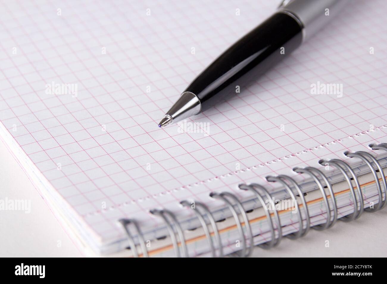 spiral note book with checked pages and pen Stock Photo - Alamy