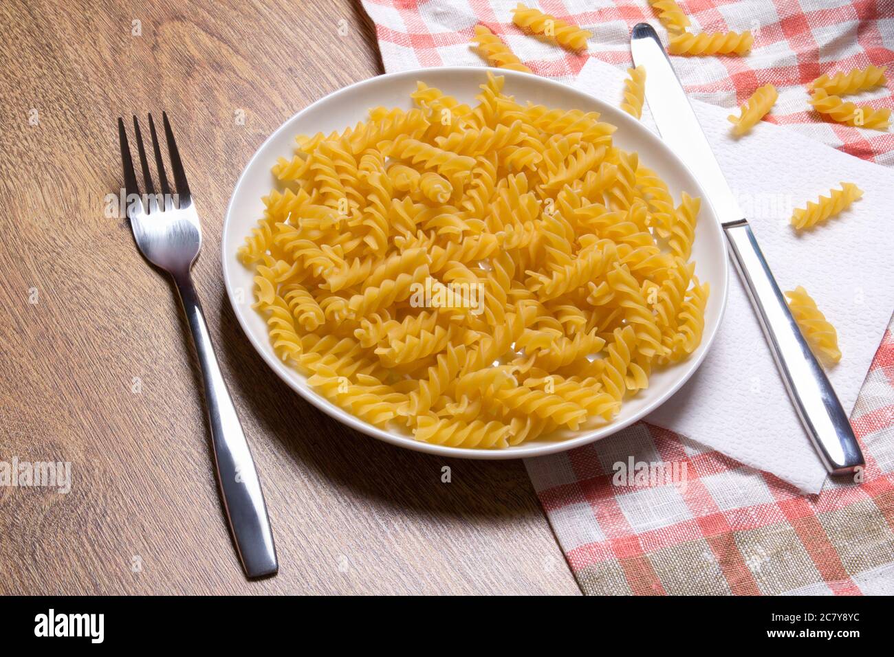 close up of raw italian spiral pasta in plate on table Stock Photo - Alamy