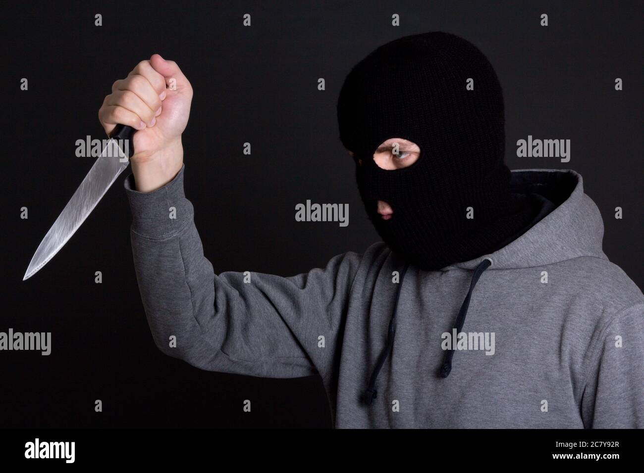 man criminal in black mask with knife over grey background Stock Photo ...