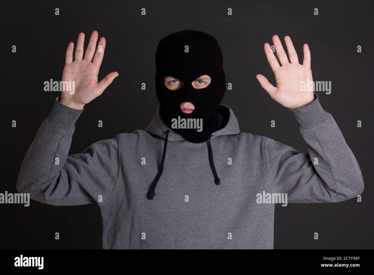 man in black mask holding hands up over grey background Stock Photo - Alamy