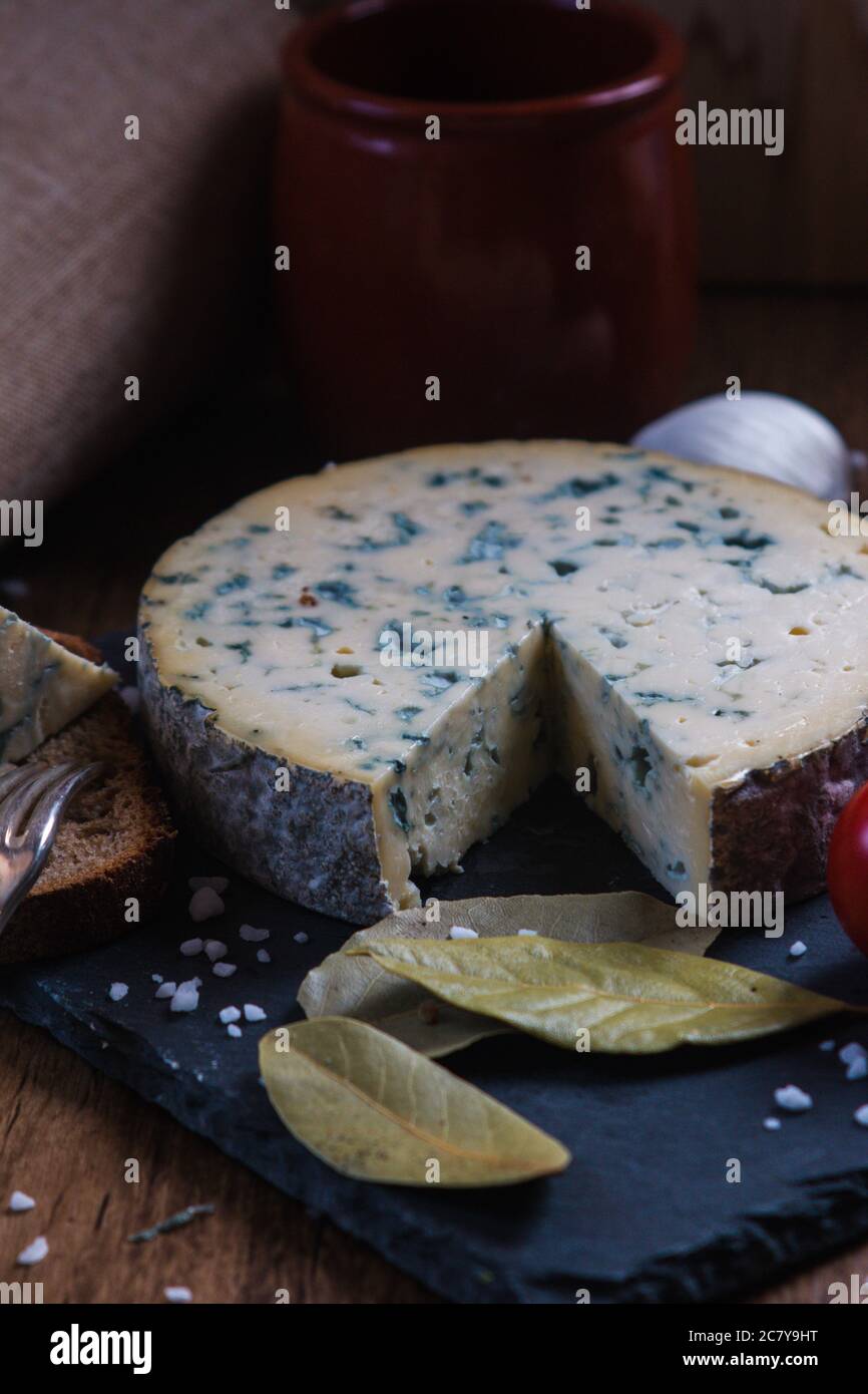 Vertical shot of blue cheese next bay leaves and a cup Stock Photo - Alamy