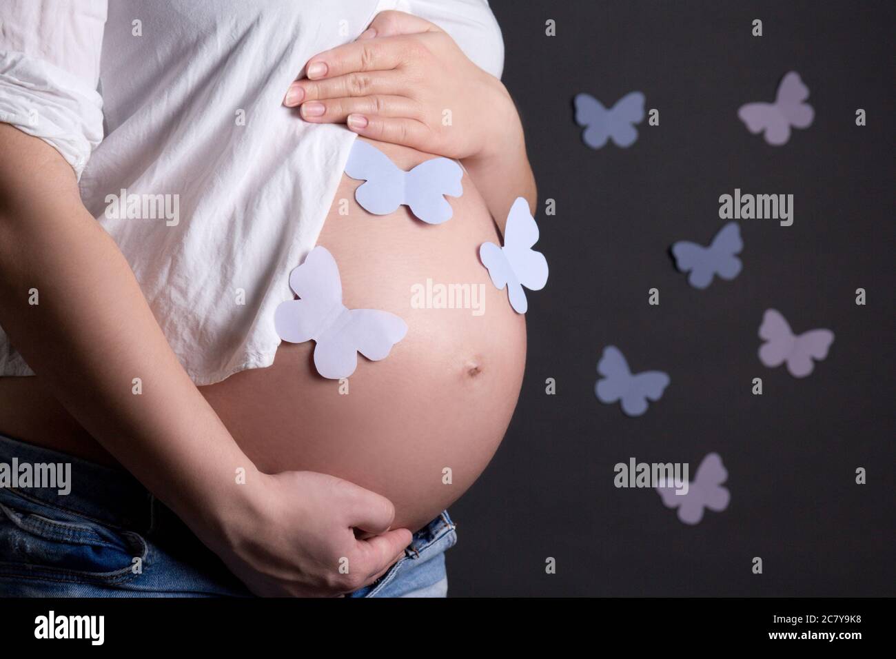 Pregnant Womans Belly With Paper Colorful Butterflies Over Grey