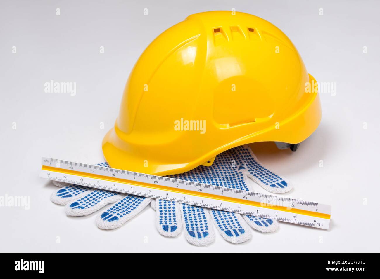 builder's tools - helmet, work gloves and ruler over white background ...