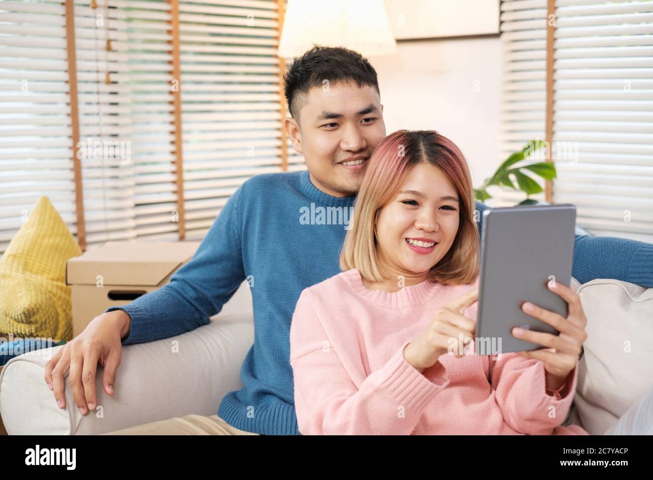 happy asian couple using tablet to design decorate new house interior ...