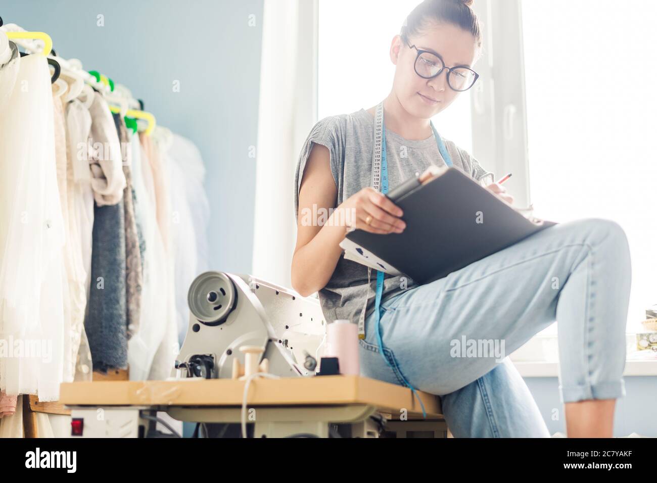 Dressmaker designing clothes pattern on paper Stock Photo - Alamy