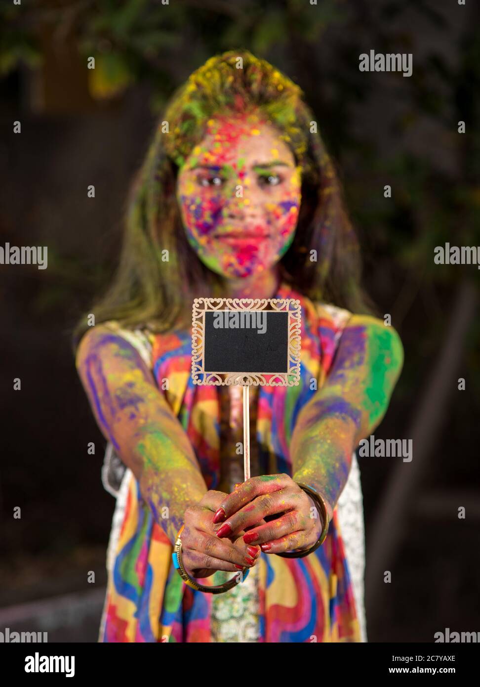 Young girl holding the small board on the occasion of Holi festival ...