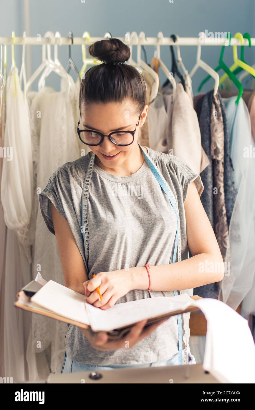 Dressmaker designing clothes pattern on paper Stock Photo - Alamy