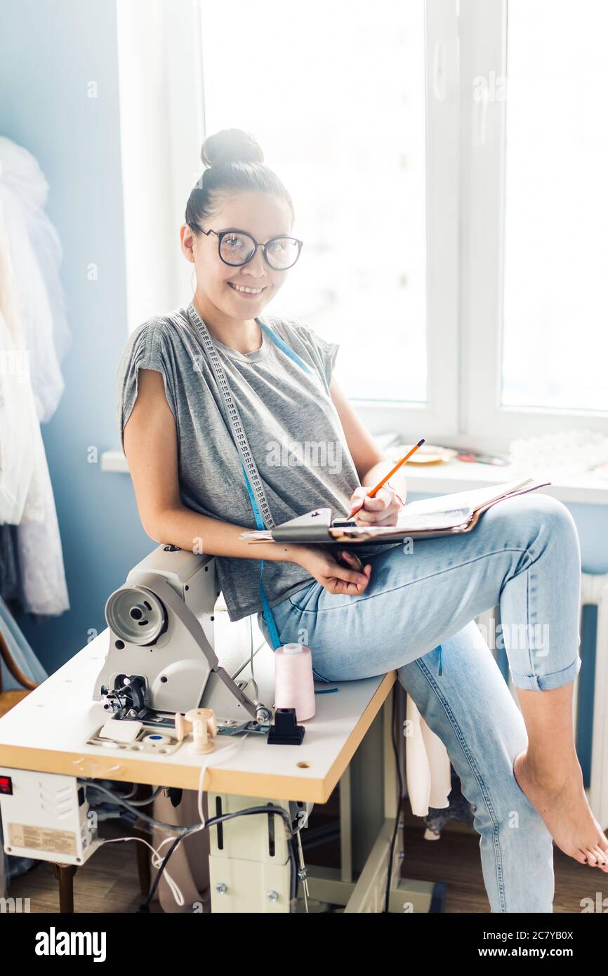 Dressmaker designing clothes pattern on paper Stock Photo - Alamy