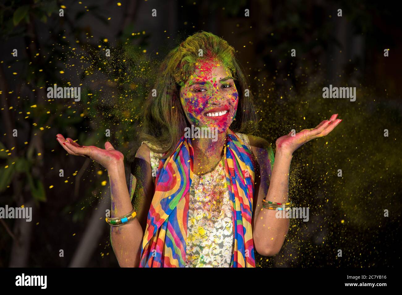 A young girl plays with colors. The concept for Indian festival Holi ...