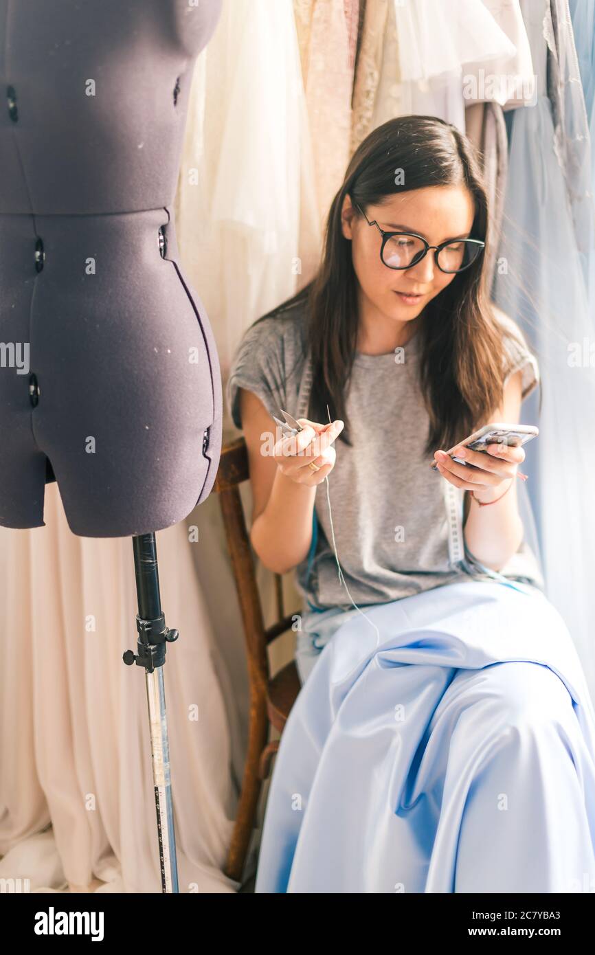Female dressmaker using smartphone work hi-res stock photography and ...