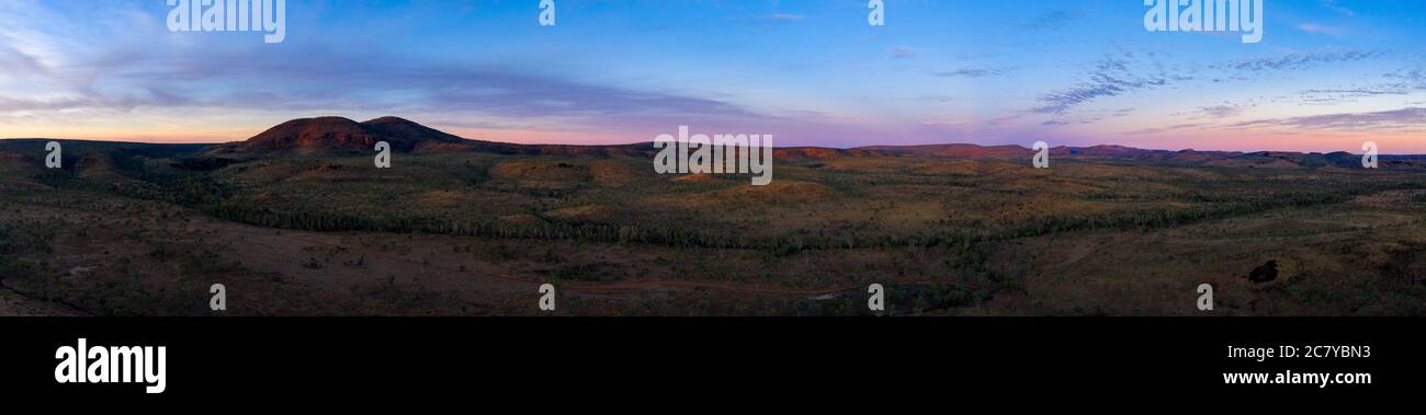 Panoramic shot of a beautiful landscape in a blue-violet shaded sunset ...
