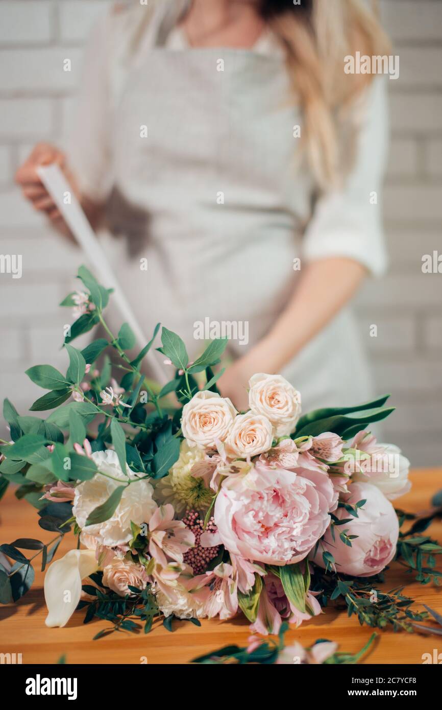 florist ties the bouquet with a ribbon Stock Photo - Alamy