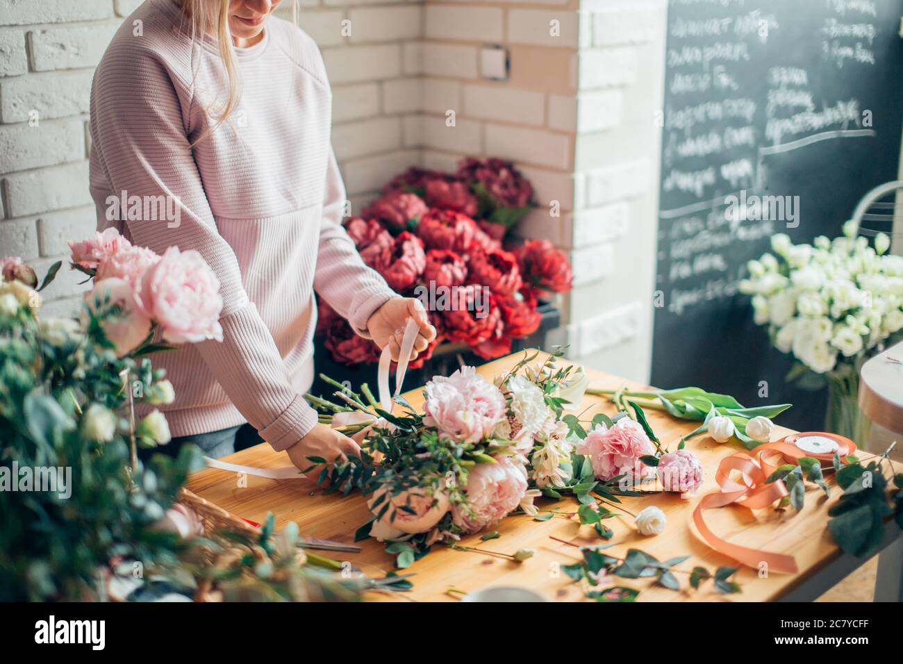 florist ties the bouquet with a ribbon Stock Photo - Alamy