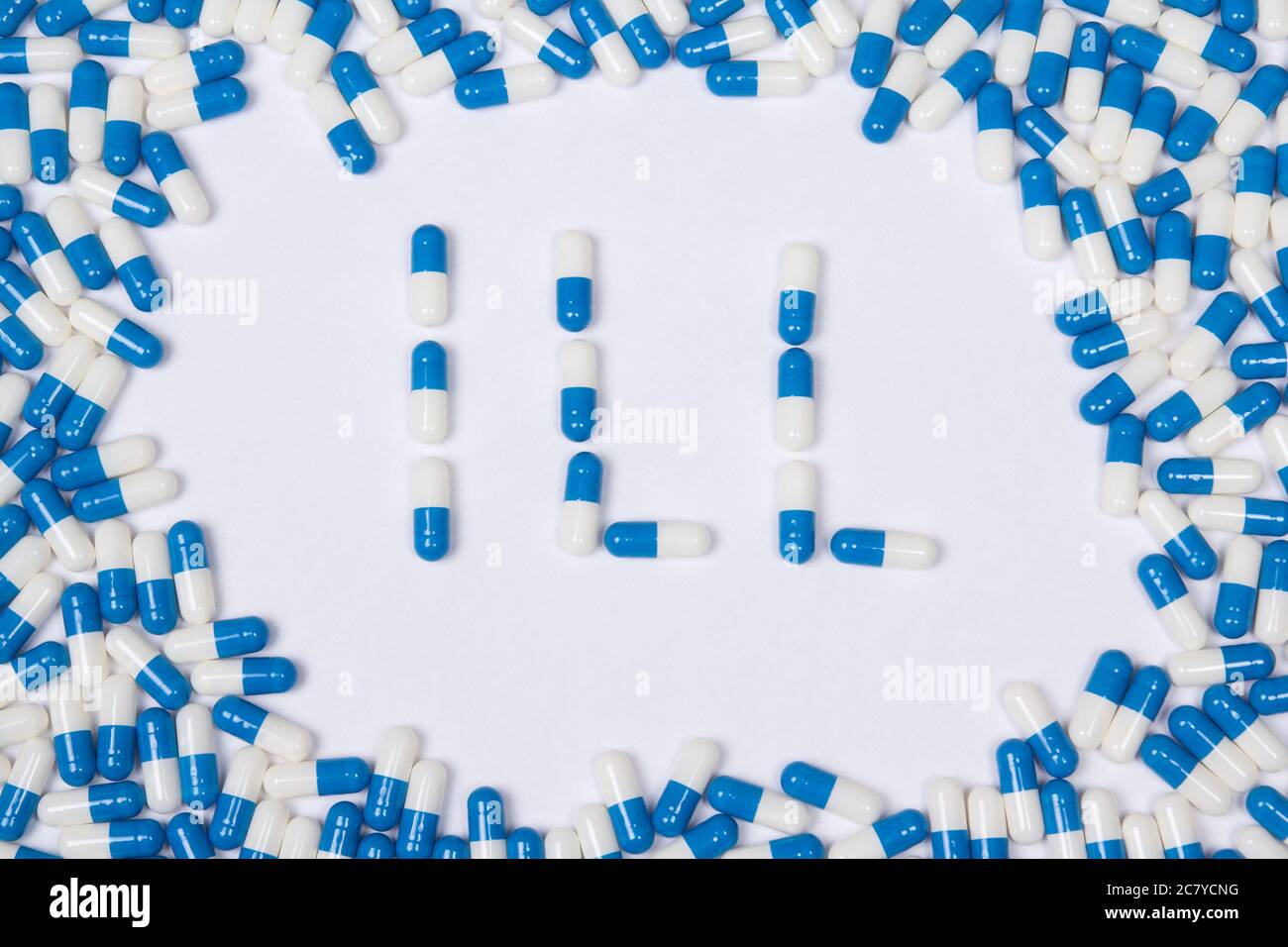 ill word text made of blue tablets, pills and capsules on white ...