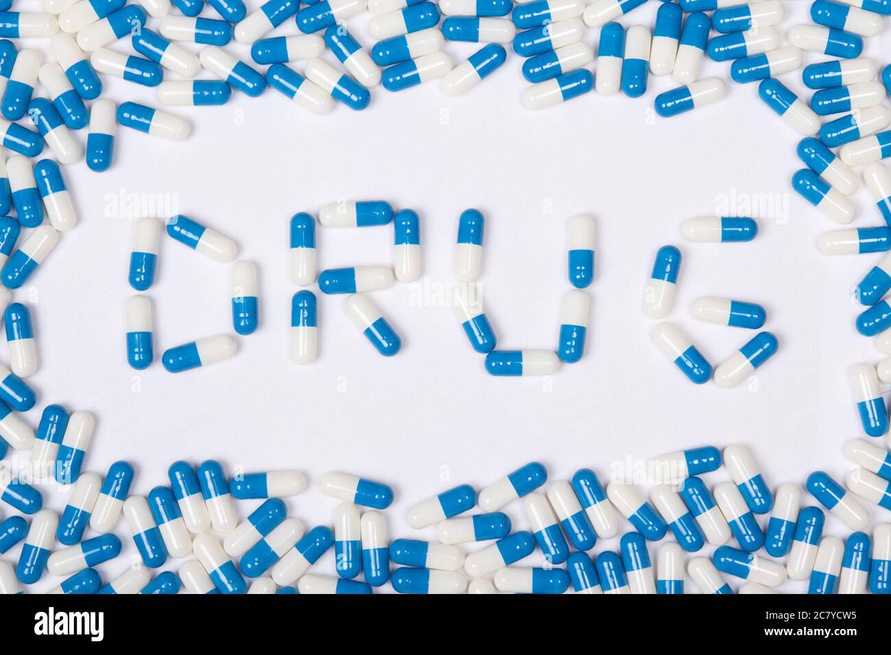 drug word text made of blue tablets, pills and capsules on white ...
