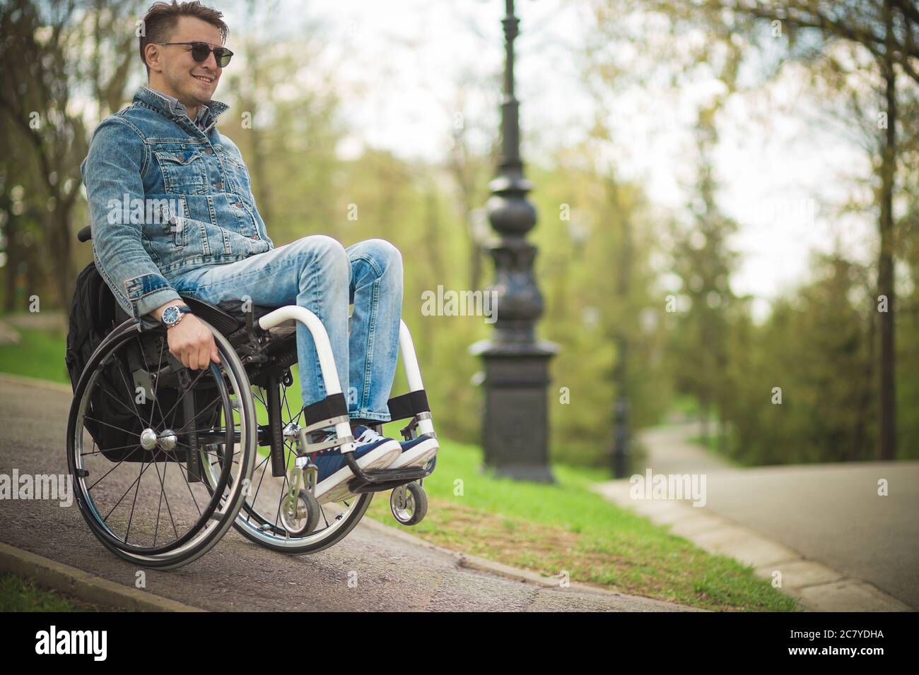 Invalid man sitting on a wheel chair and enjoying a walk outdoors Stock ...