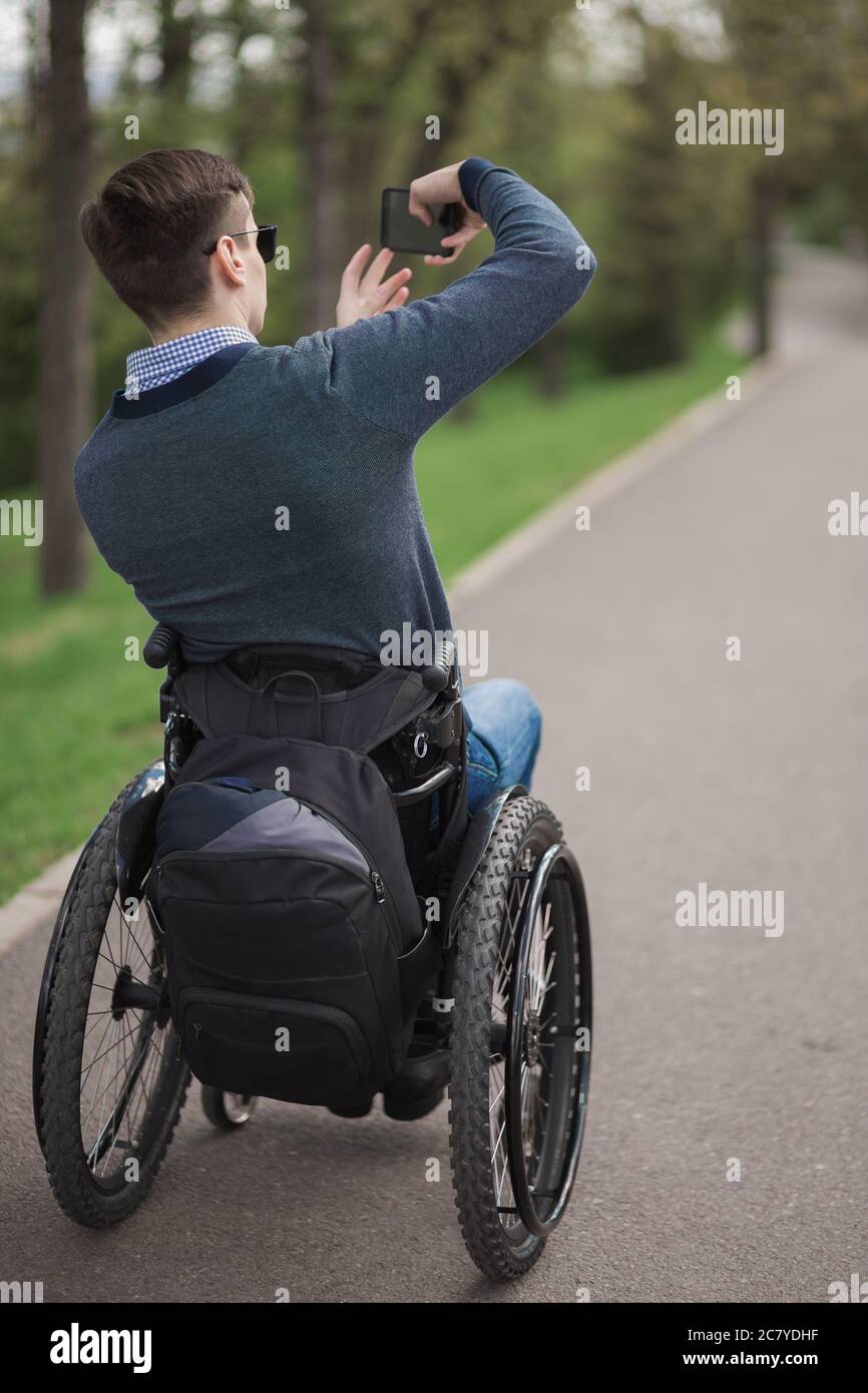 Invalid man sitting on a wheel chair and enjoying a walk outdoors Stock ...