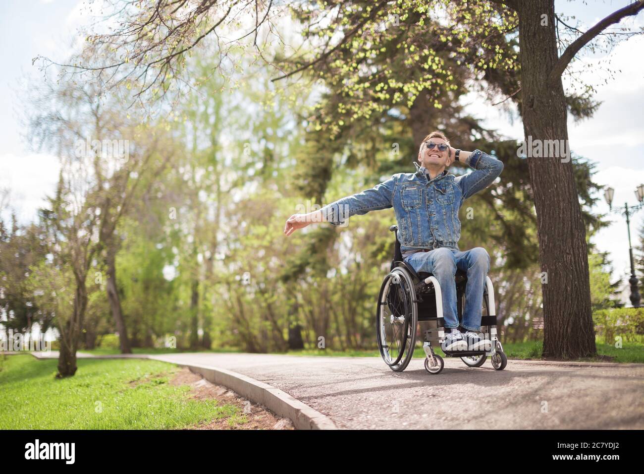 Invalid man sitting on a wheel chair and enjoying a walk outdoors Stock ...