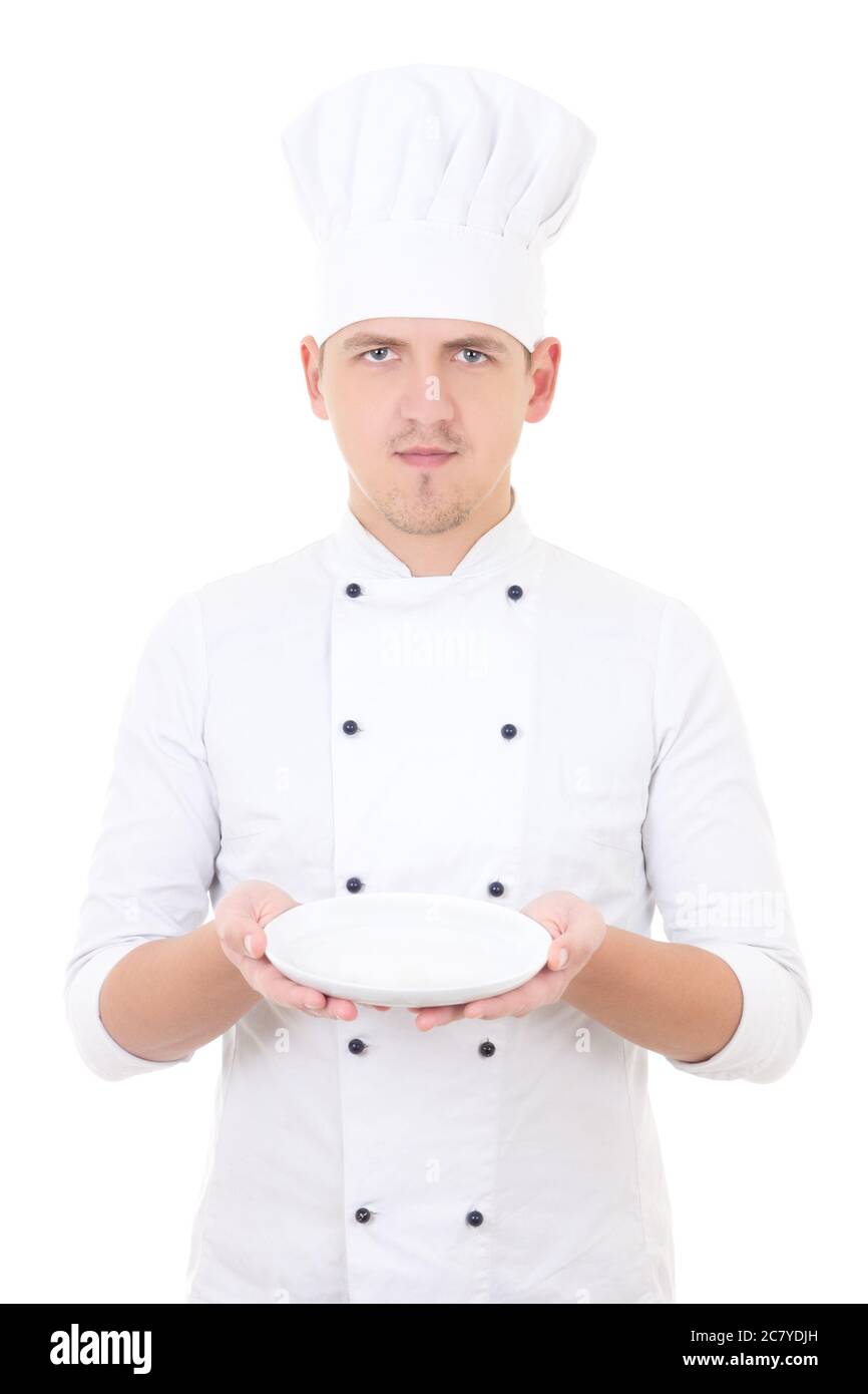 young man chef in uniform showing empty plate isolated on white ...