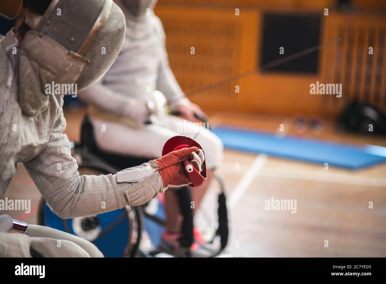 Close-up of man fencer hends wearing white fencing costume and holding ...