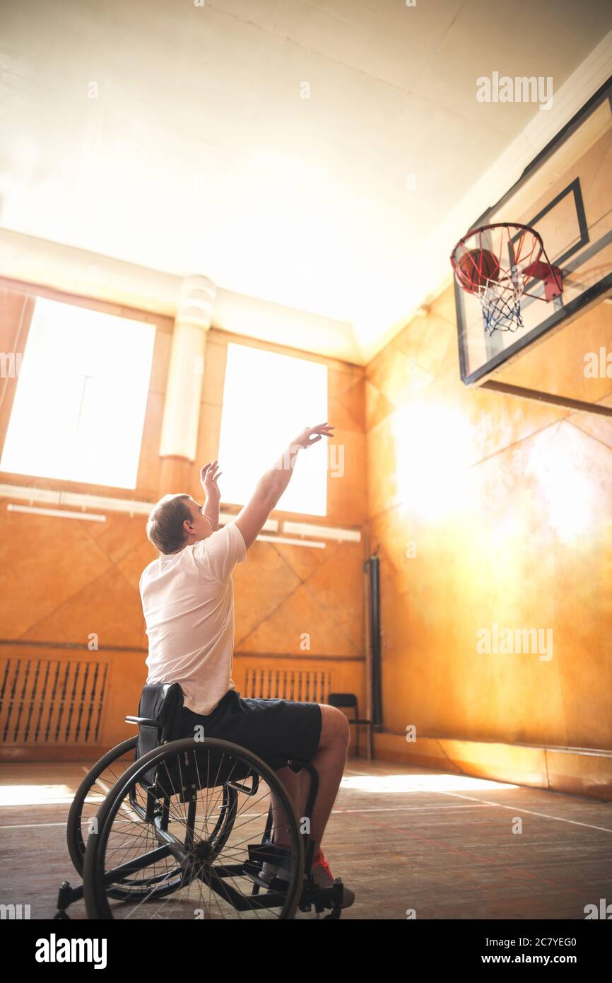 rear view of a basketball player in free throw pose in wheelchair at ...