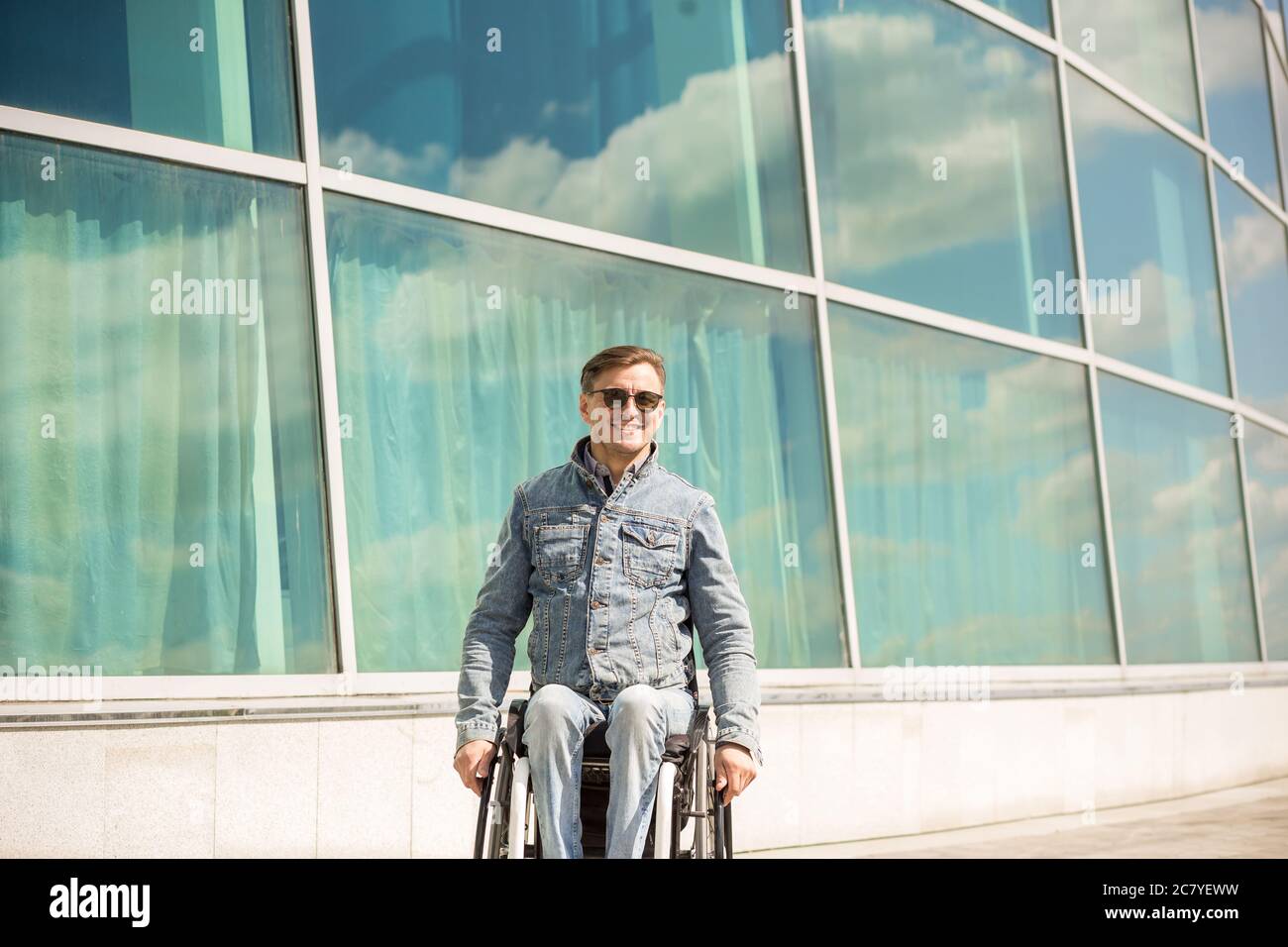 Invalid man sitting on a wheel chair and enjoying a walk outdoors Stock ...