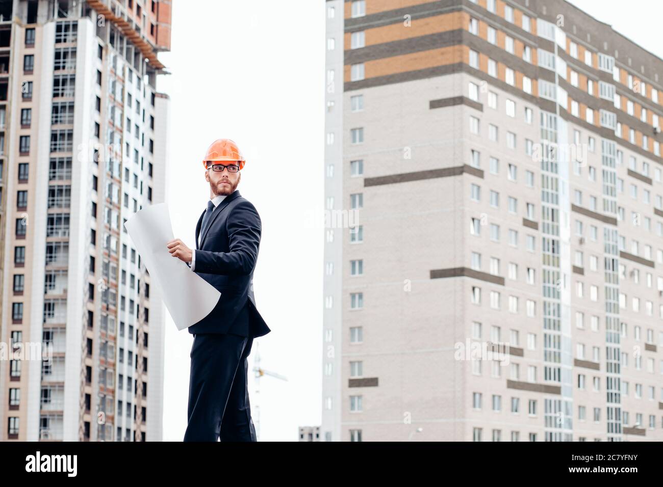 Portrait of an architect builder studying layout plan of the rooms ...