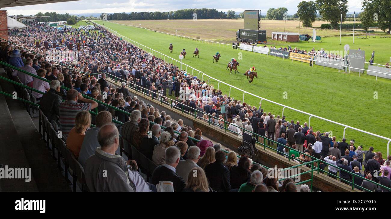 Crowds of spectators watch a horse race at Thirsk racecourse in North ...